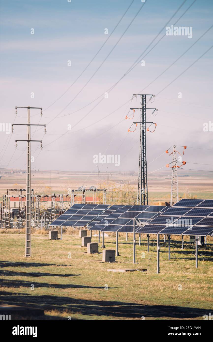 Modern solar panels installed in field against cloudy sky in ...