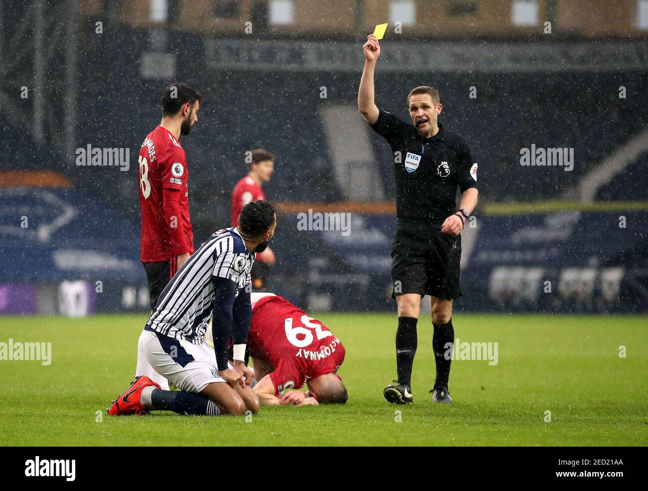 Referee craig pawson shows yellow card hi-res stock photography and ...