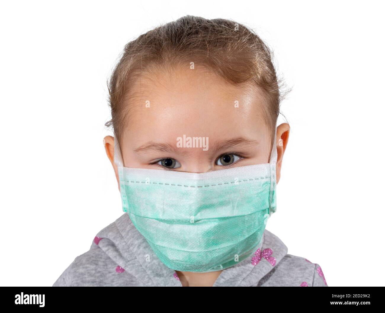 Adorable little girl wearing green protective surgical face mask ...