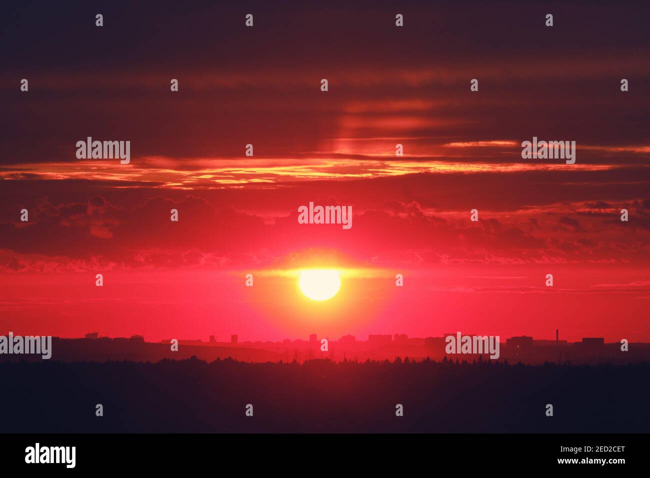 The silhouette of the night city in the light of the setting red sun ...