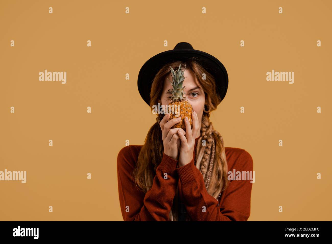 Photo of cute female farmer holds pineapple and covers face up. White ...