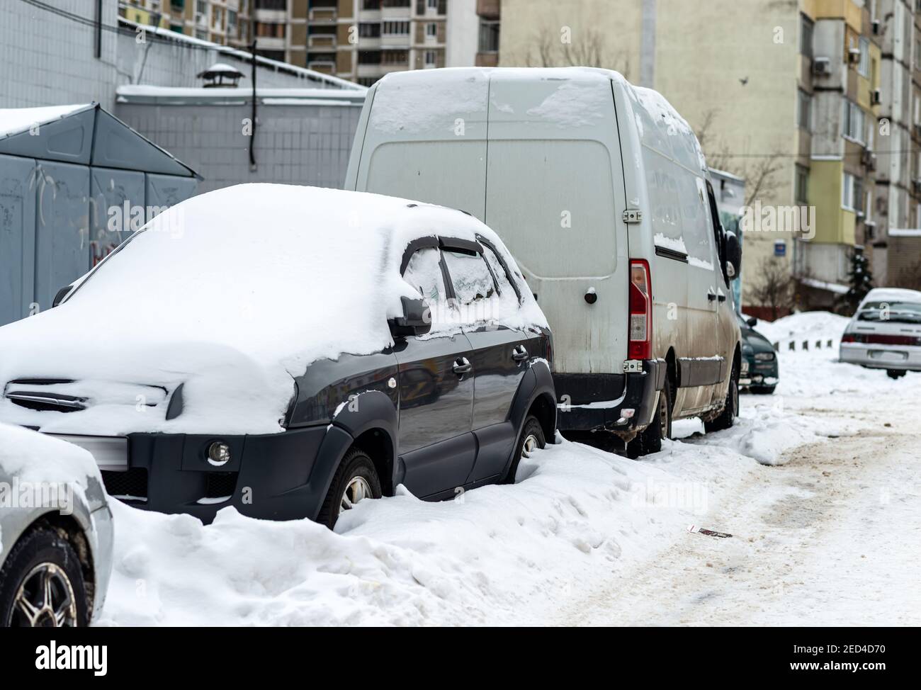 Cars stand in the yard covered with snow Stock Photo - Alamy