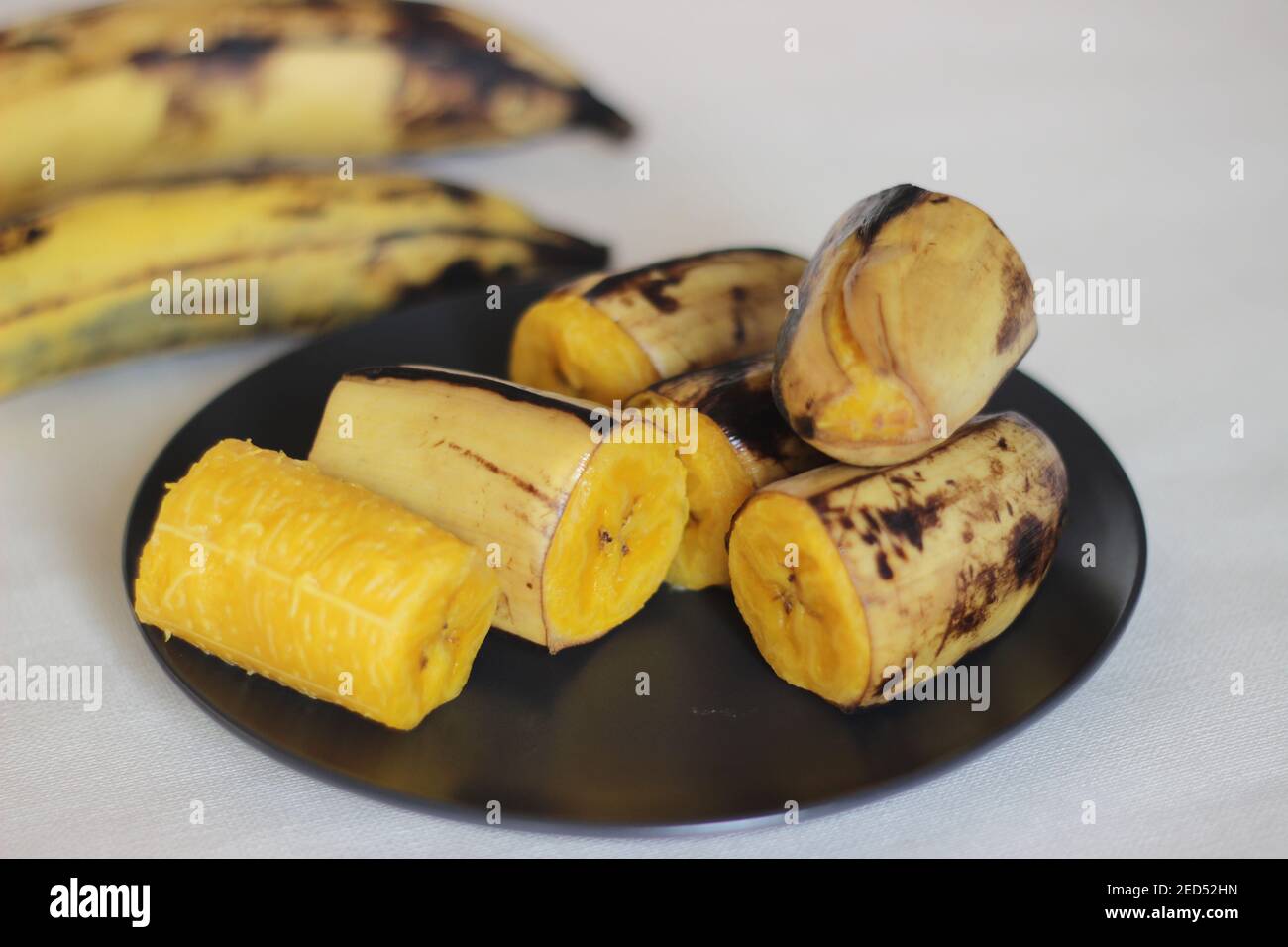 Ripe plantain Steamed and served on dark grey medium size plate. Shot ...
