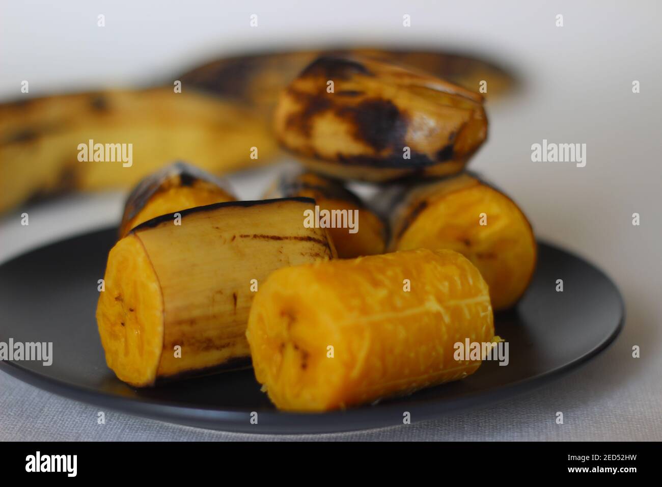 Ripe plantain Steamed and served on dark grey medium size plate. Shot ...