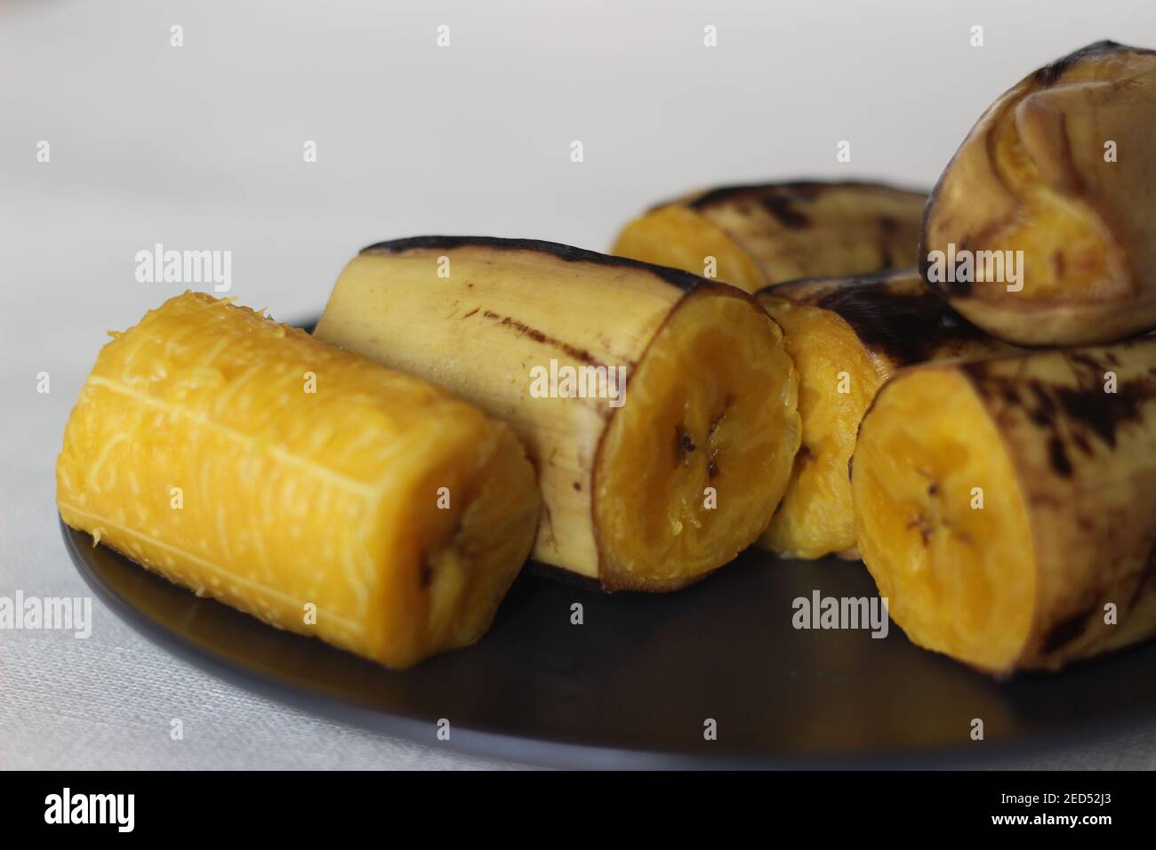 Ripe plantain Steamed and served on dark grey medium size plate. Shot ...