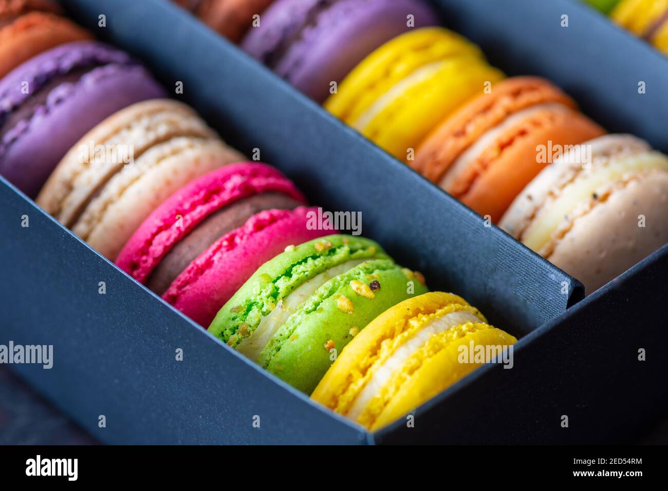 Various colorful macarons or French macaroons in a row in a gift box ...