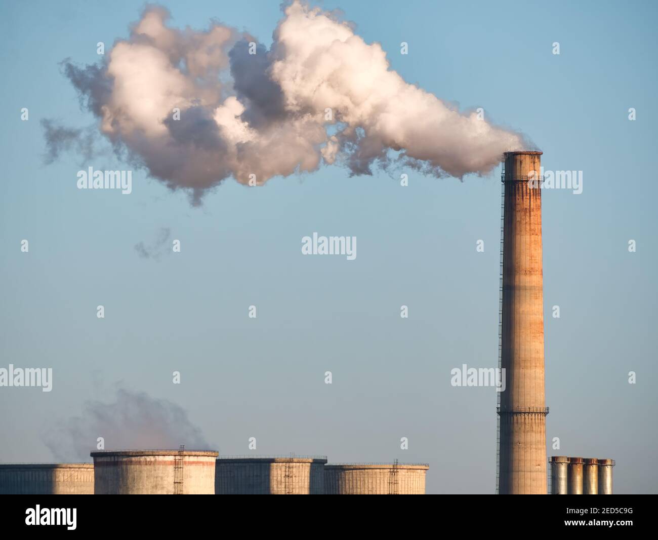 Dense smoke and steam coming out from the industrial chimney ...