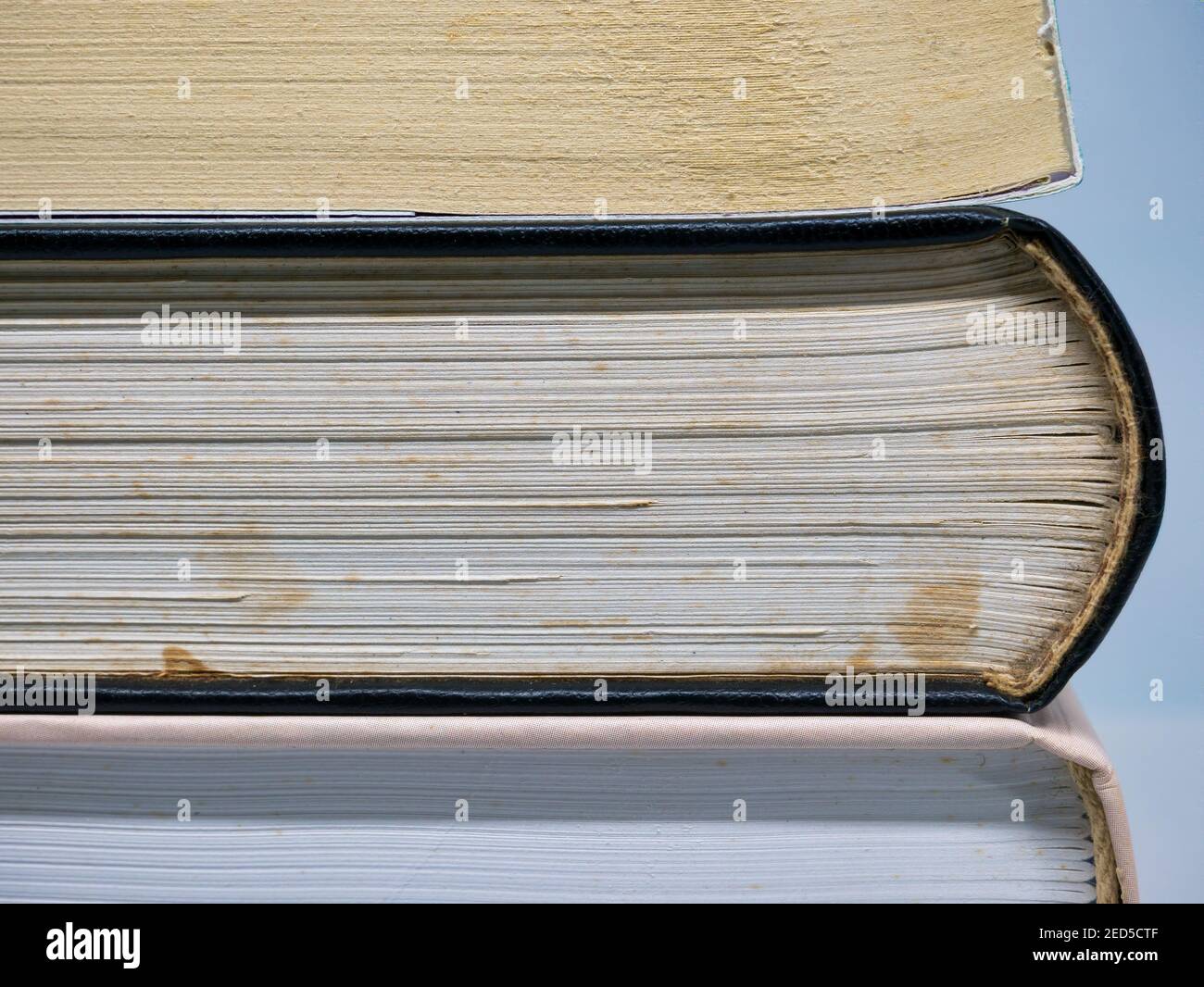 Close up with three thick stacked books Stock Photo - Alamy