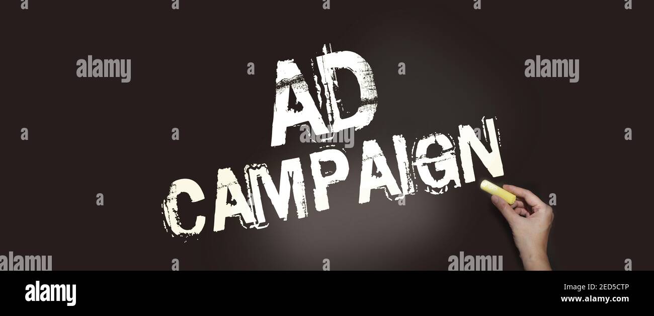 AD campaign and hand writing ir on blackboard with piece of chalk ...
