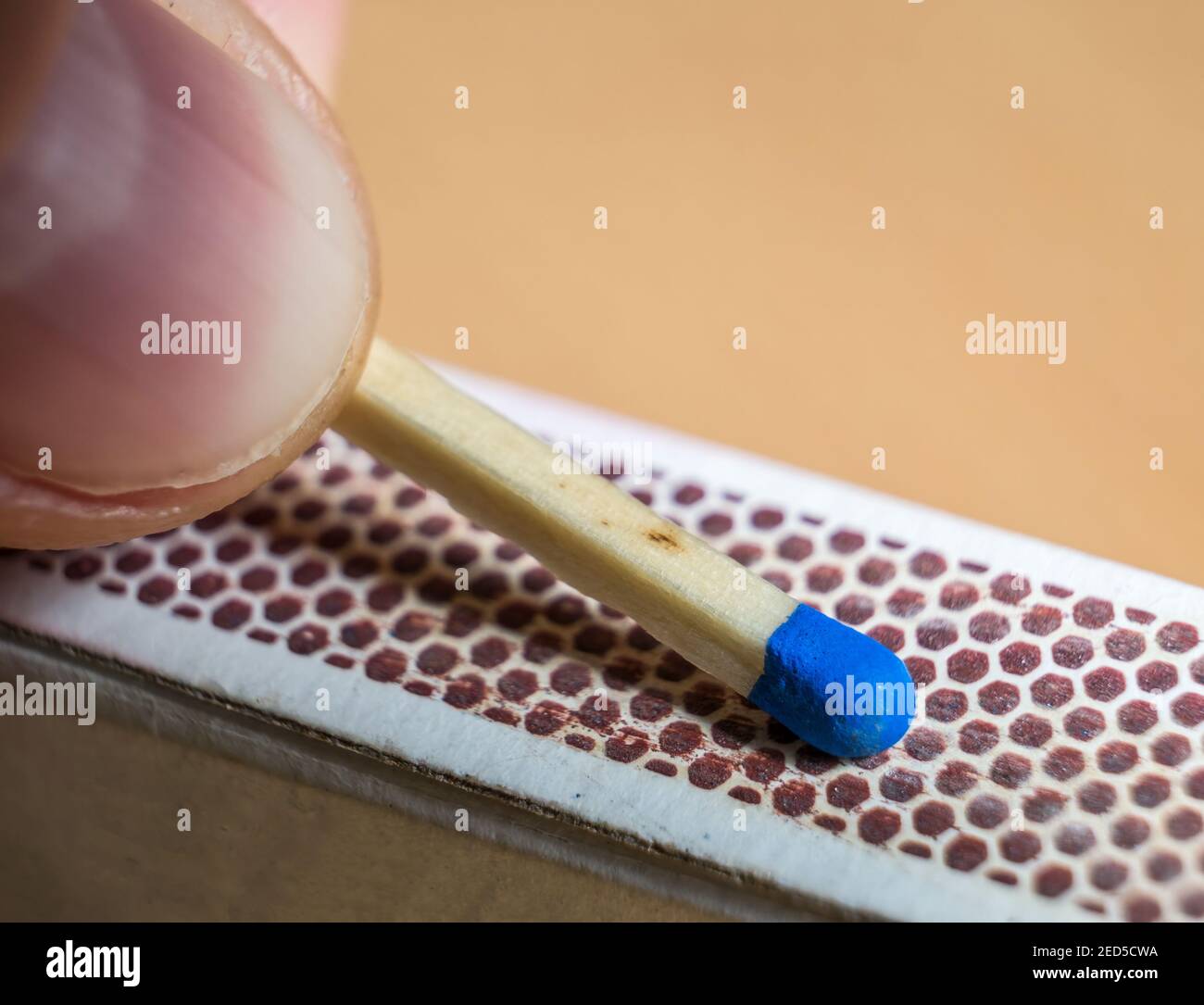 Hand swiping a matchsticks from the striking surface of the matchbox ...