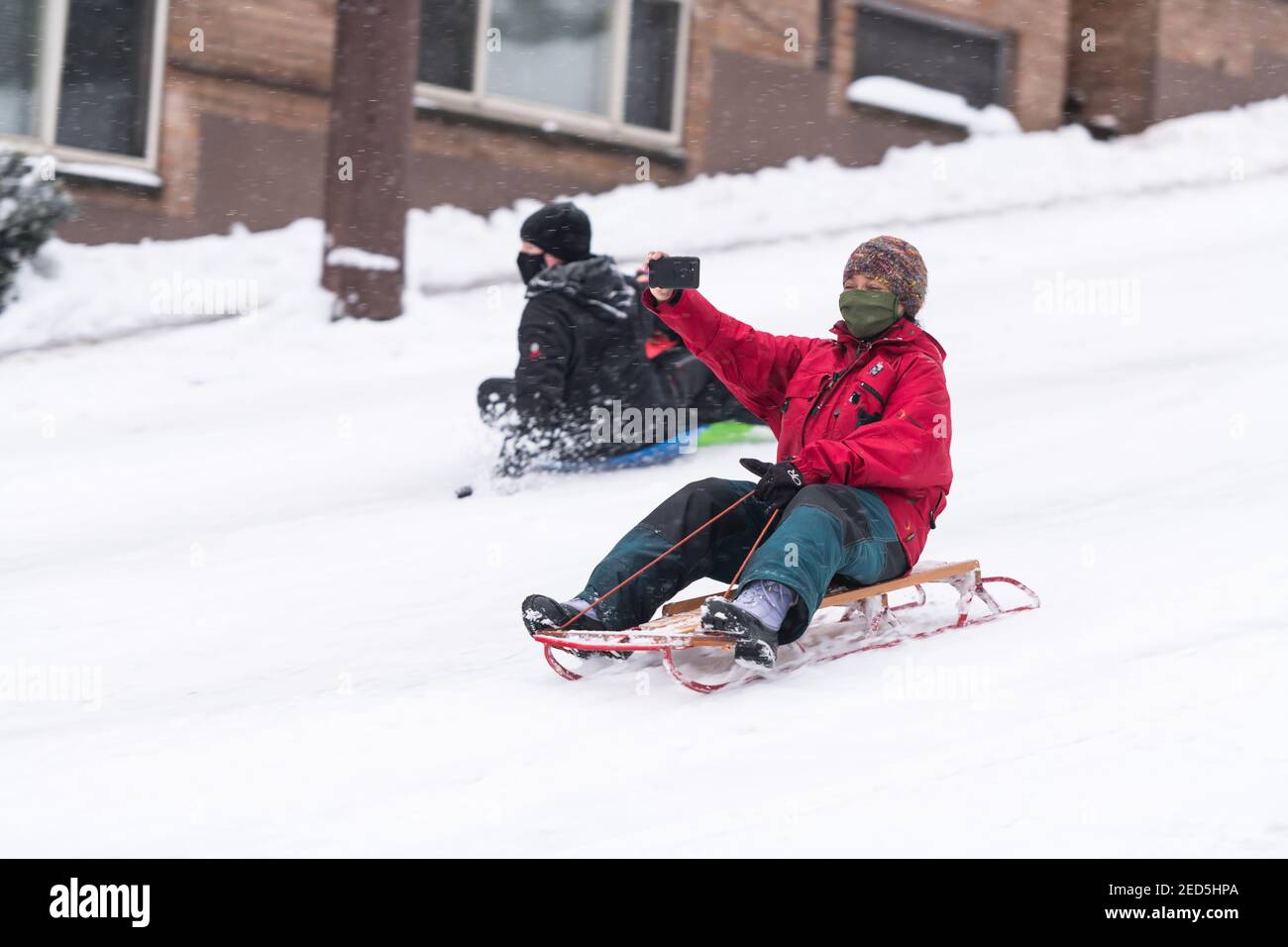 Seattle, USA. 13th Feb, 2021. Mid-day people sledding on Queen Anne Ave ...