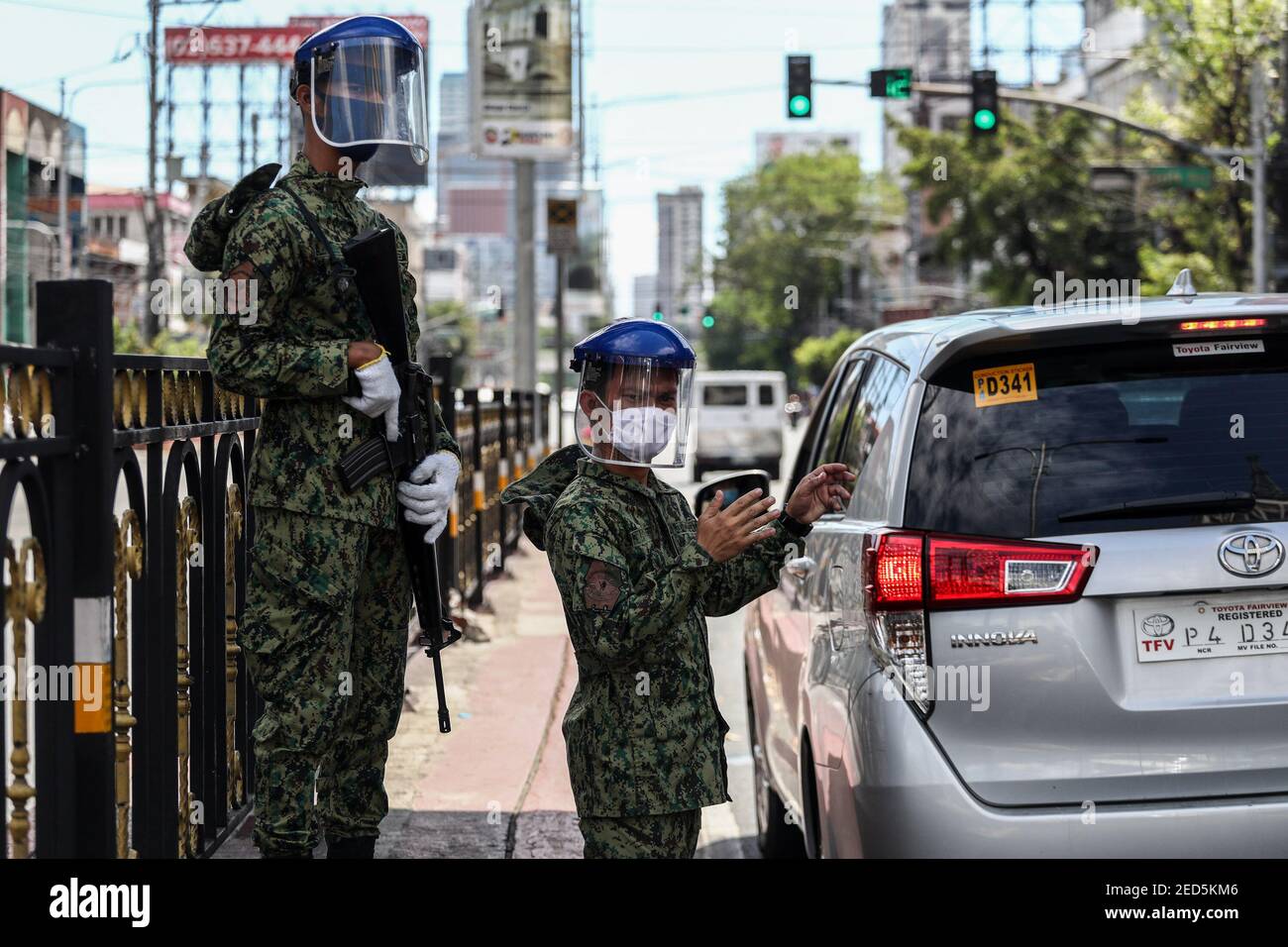 Policemen wearing protective face shields and masks stop and inspect ...