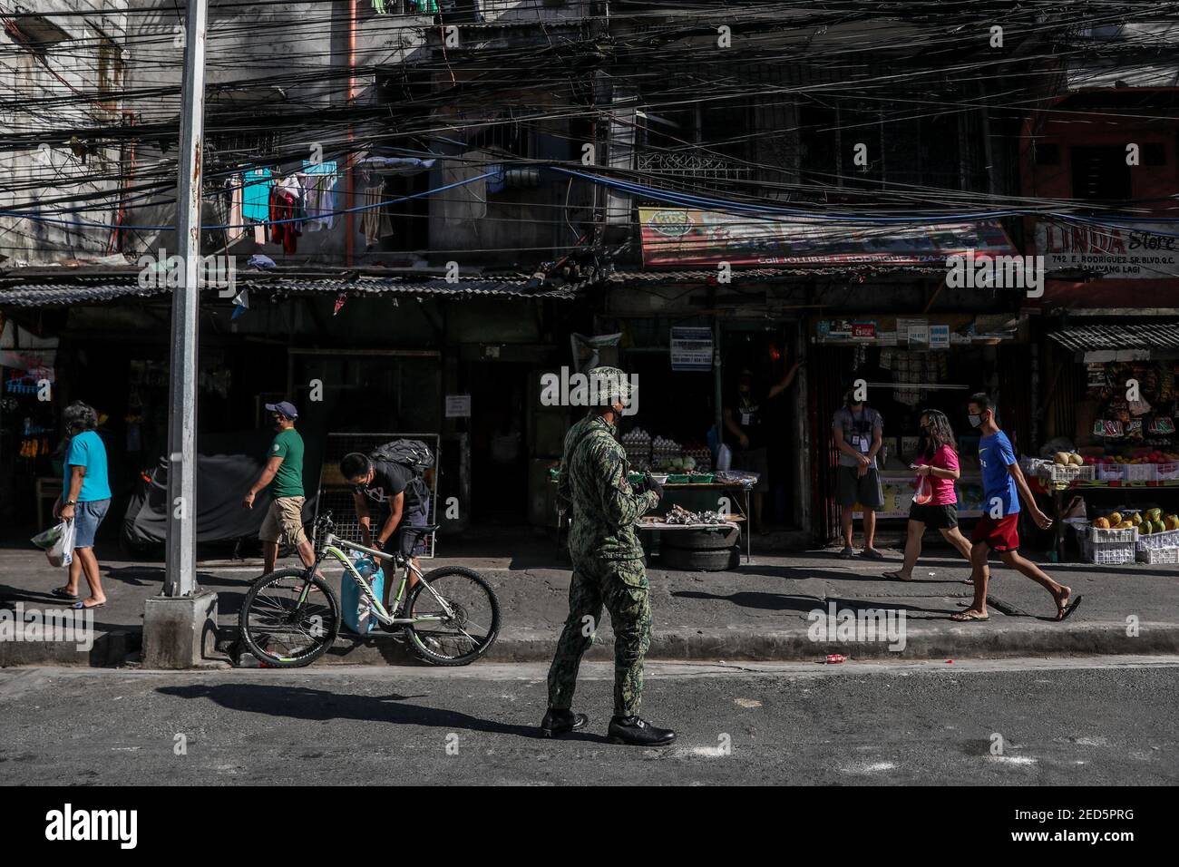 A policeman stands along a street to check that enough social distance ...