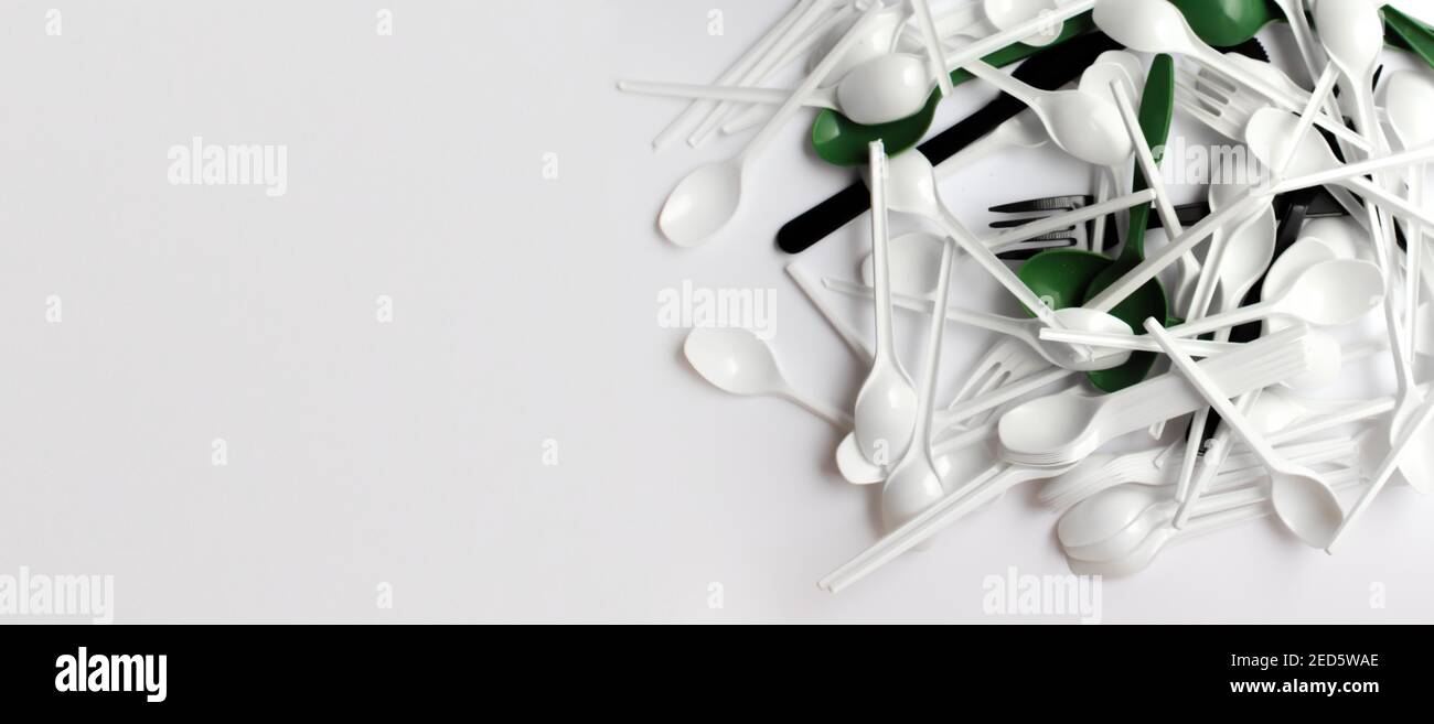 Banner lot of disposable plastic tableware on a white background ...