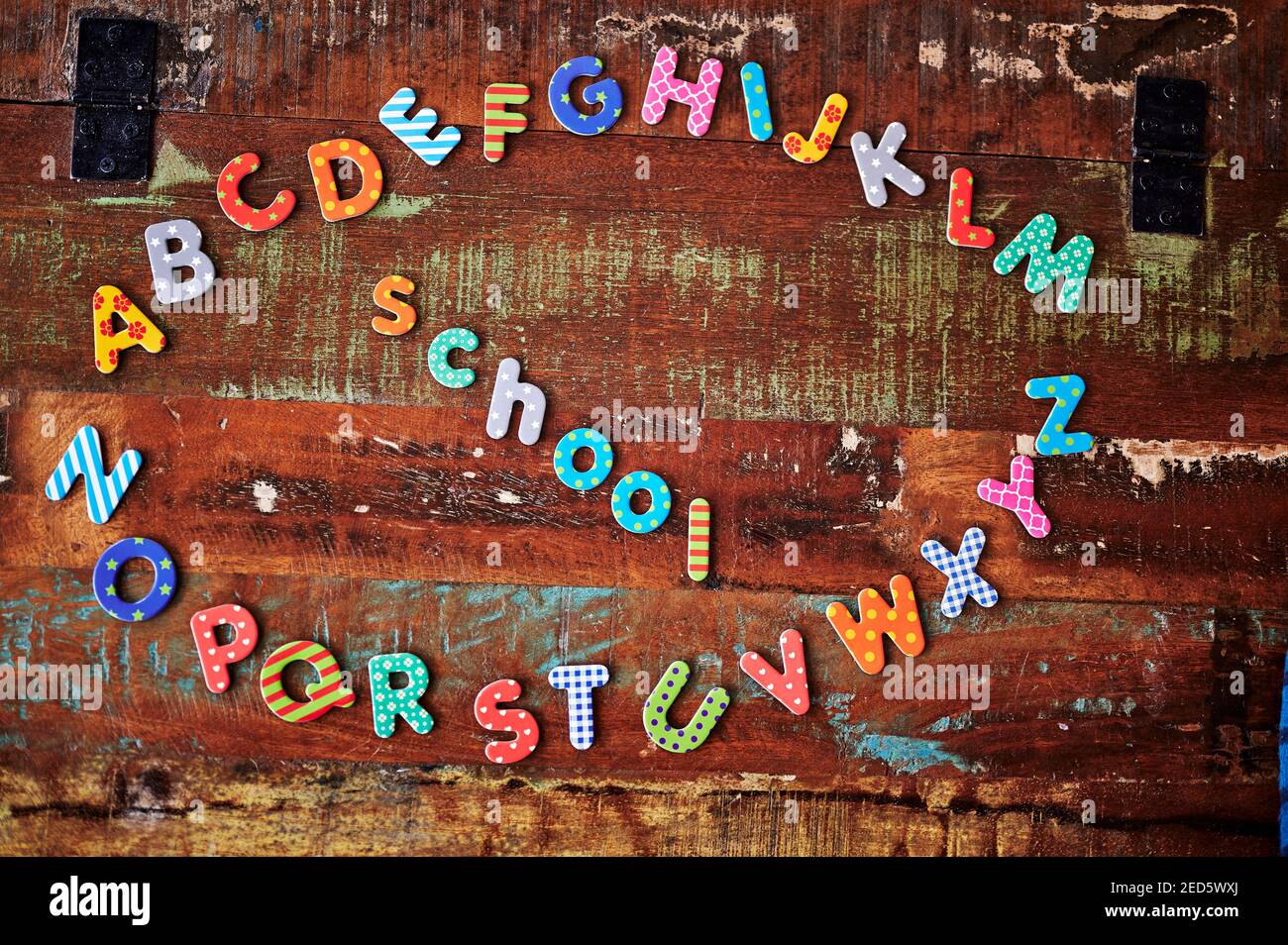 Auburn wooden table with colorful letters that show the alphabet lying ...
