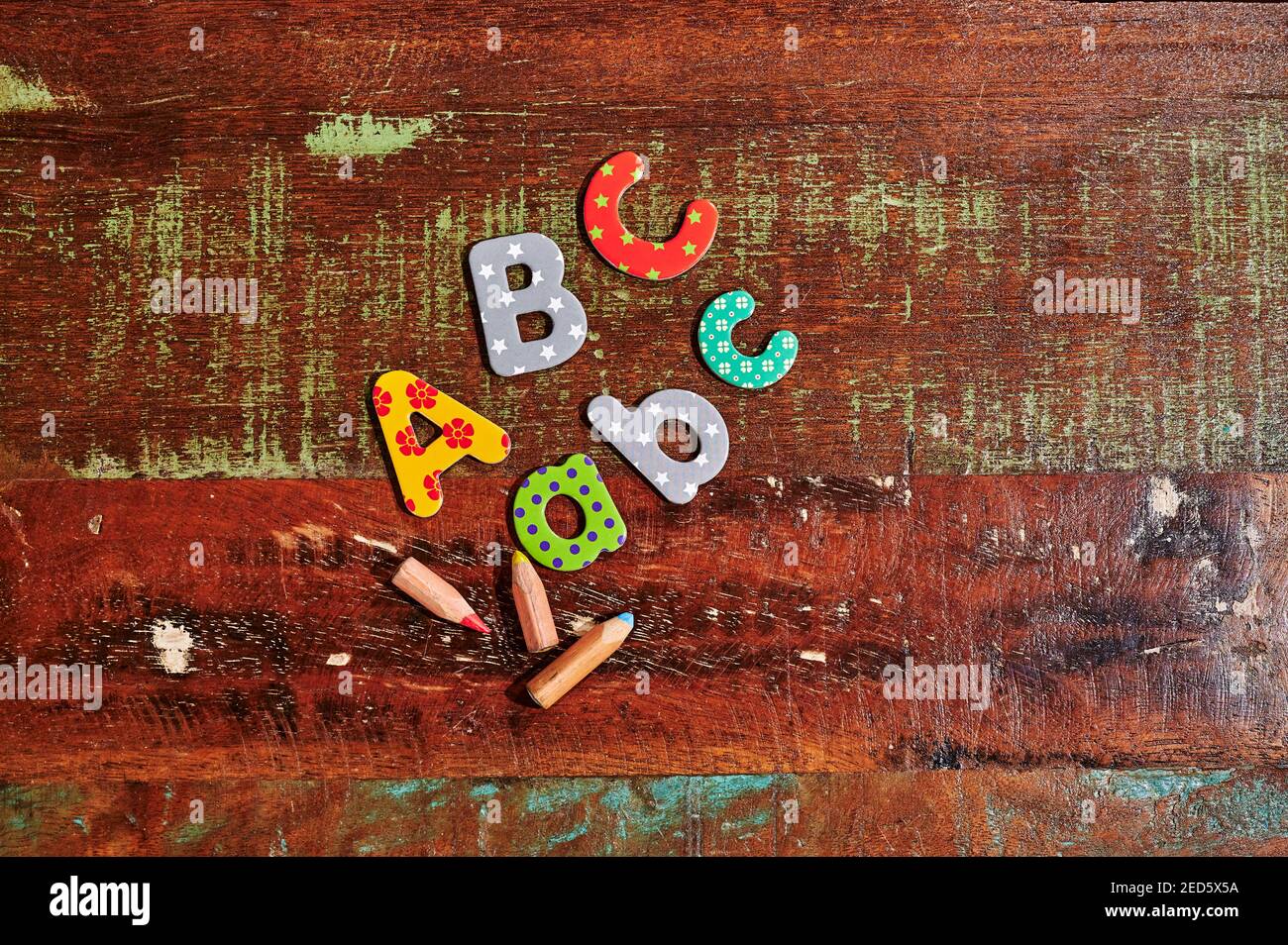 Auburn wooden table with colorful letters that make up the term ABC ...