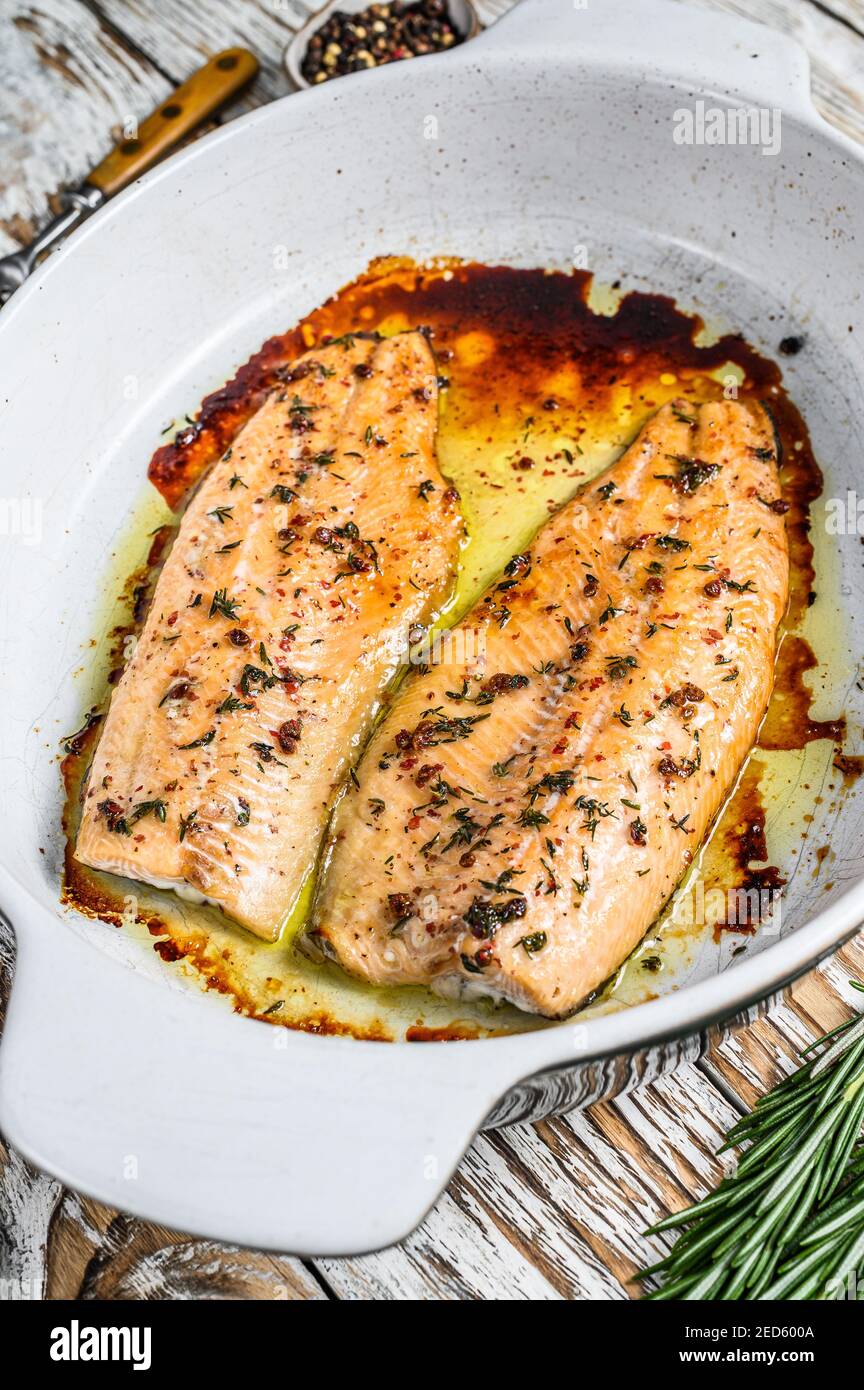 Oven Baked salmon or trout fillet. White woodenbackground. Top view ...