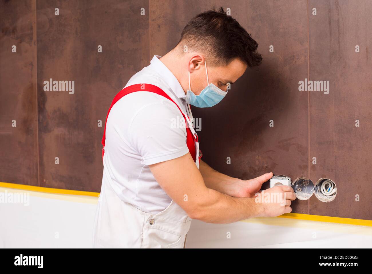 The electrician is fixing electrical wires for wall socket Stock Photo ...