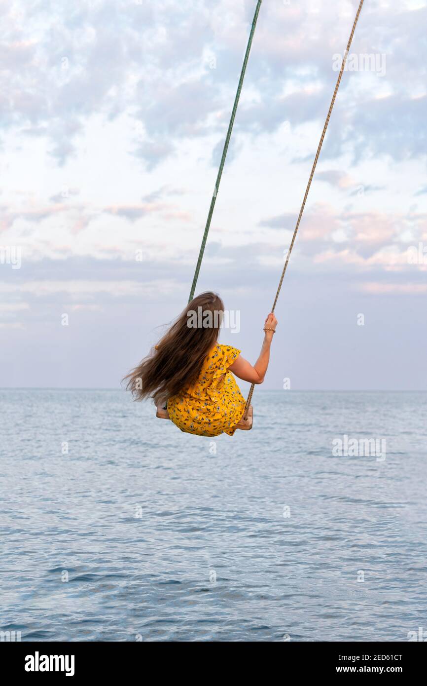 Girl swinging over sea hi-res stock photography and images - Alamy