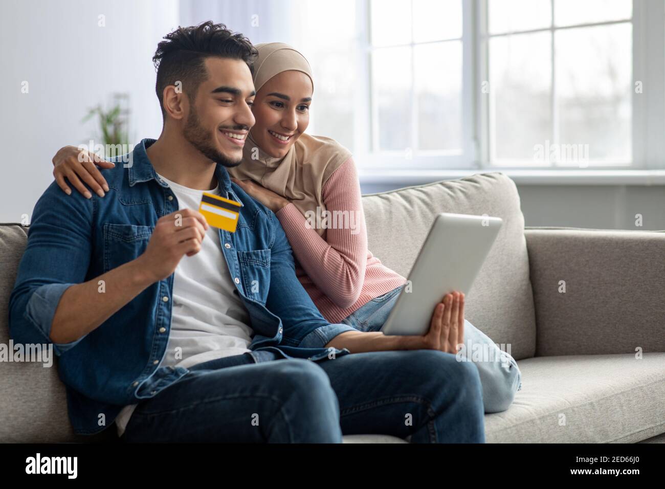 Smiling muslim couple with digital tablet and credit card Stock Photo ...