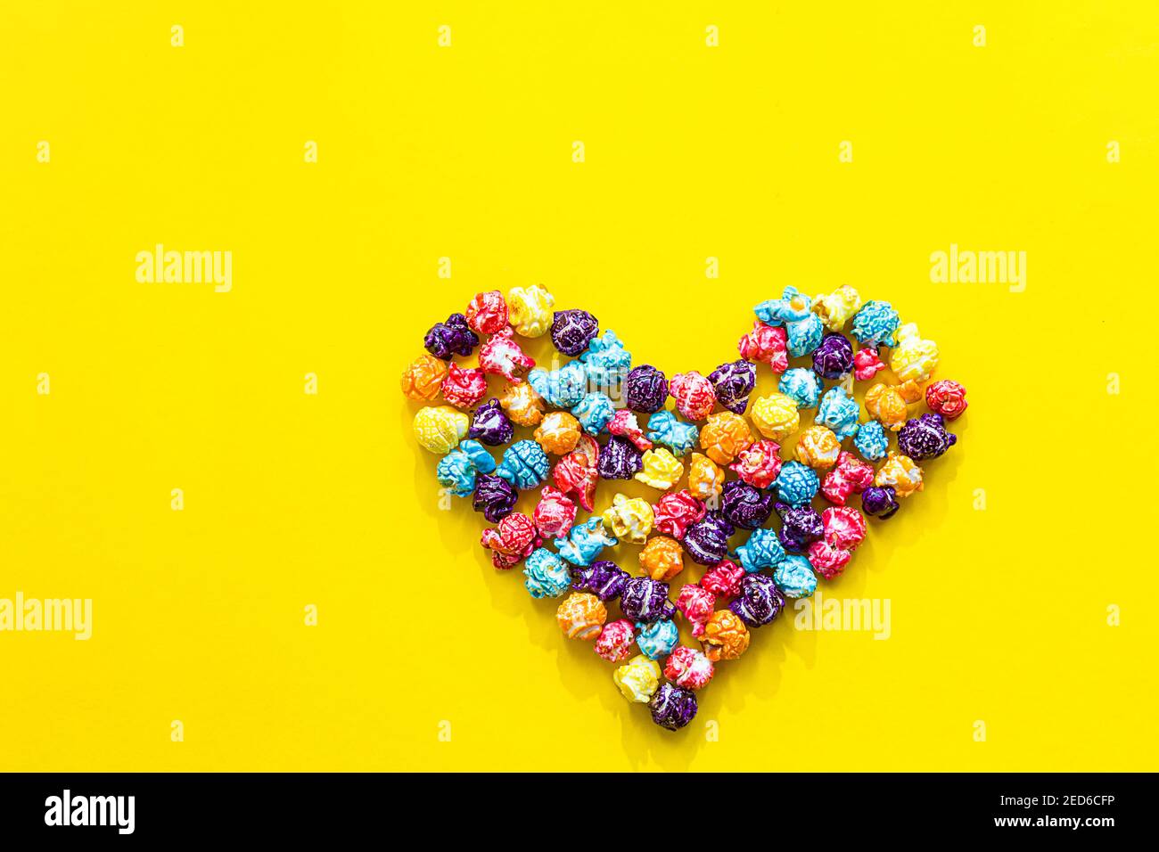 Colored popcorn. Heart shape made of colored popcorn, flat lay on ...