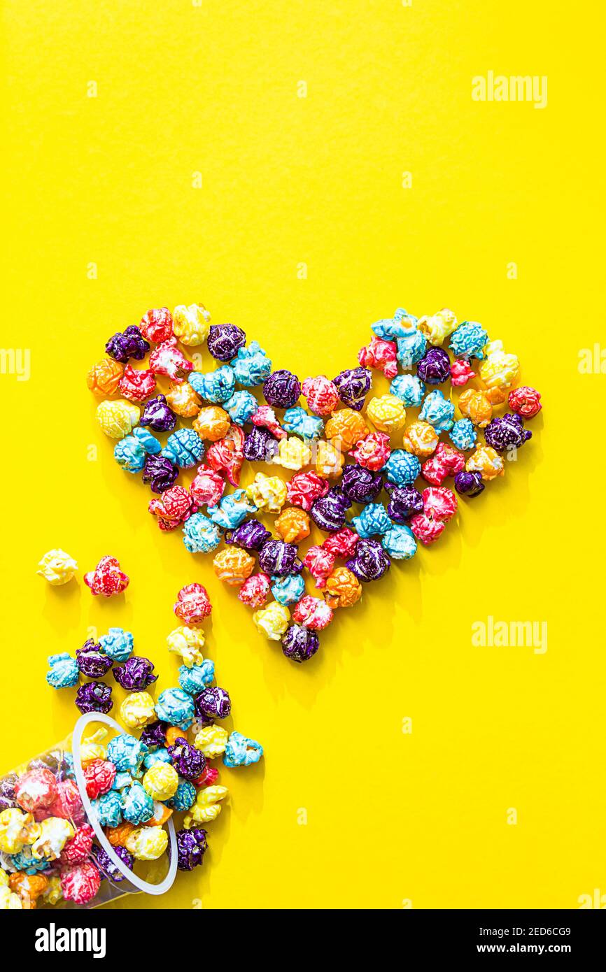 Colored popcorn. Heart shape made of colored popcorn, flat lay on ...
