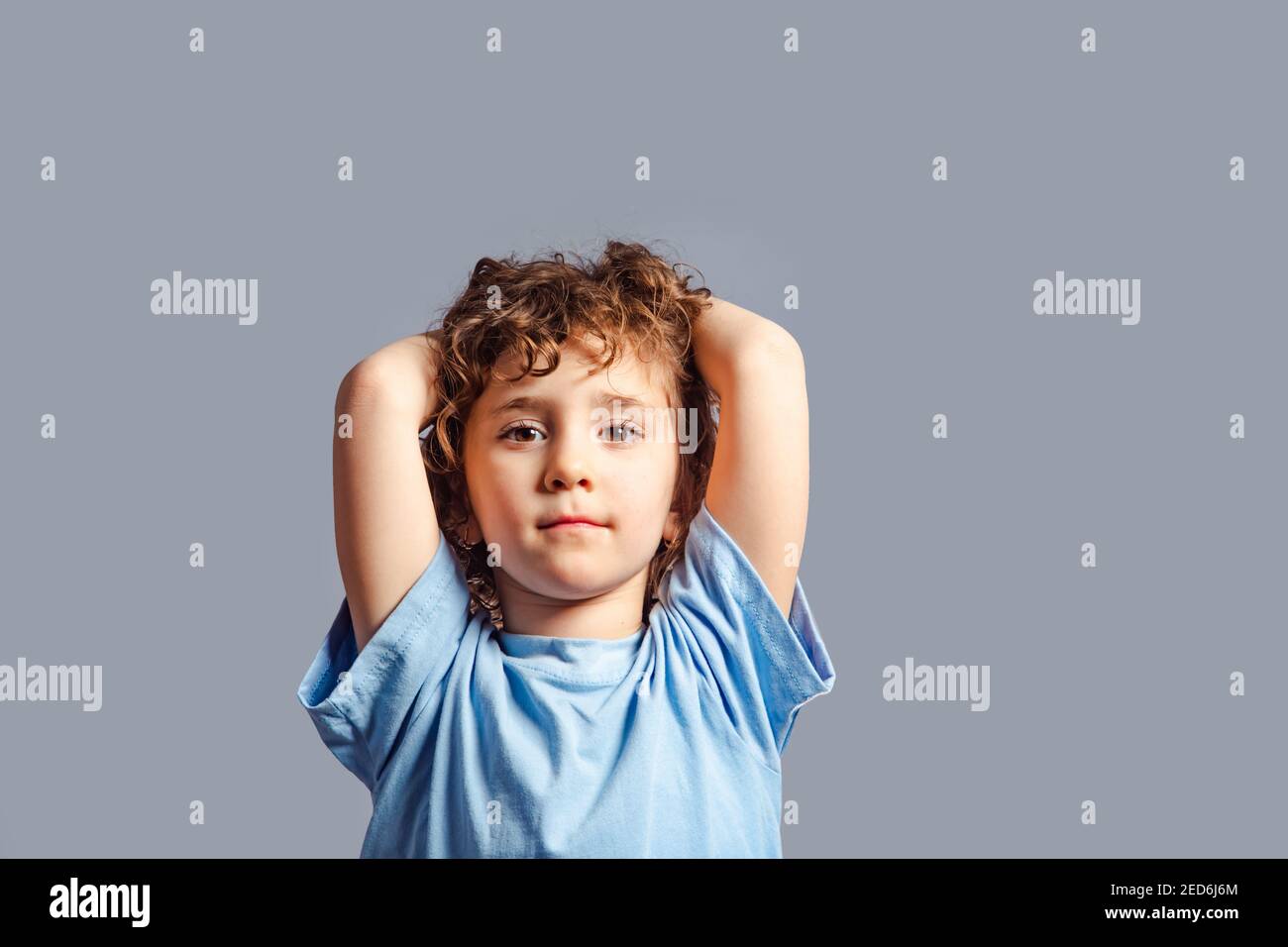 Little girl stand and thinking on a gray background Stock Photo - Alamy