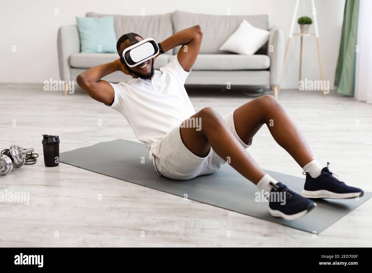 African Man Wearing VR Glasses Doing Abs Exercise At Home Stock Photo ...