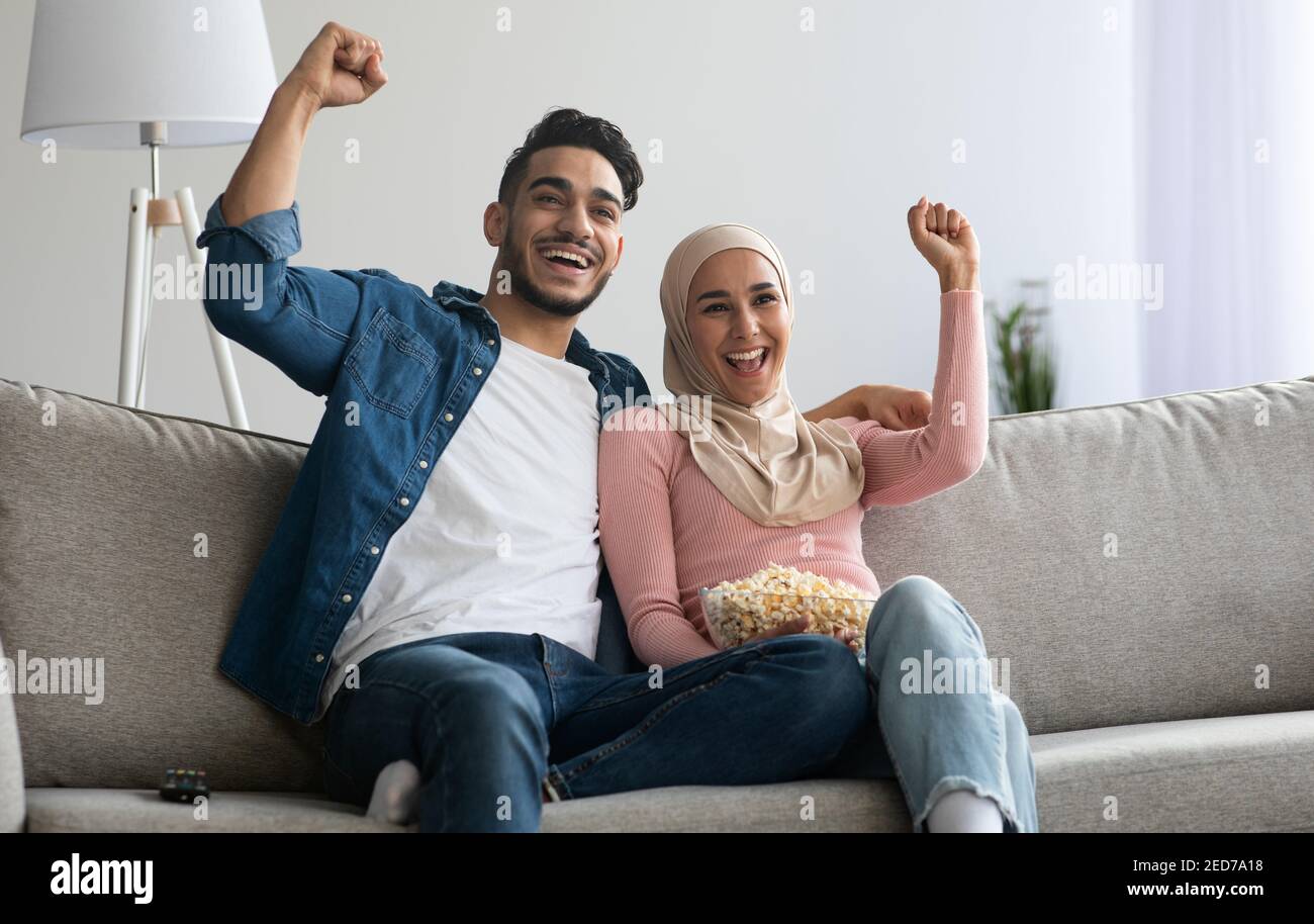 Emotional muslim couple football fans watching game Stock Photo - Alamy