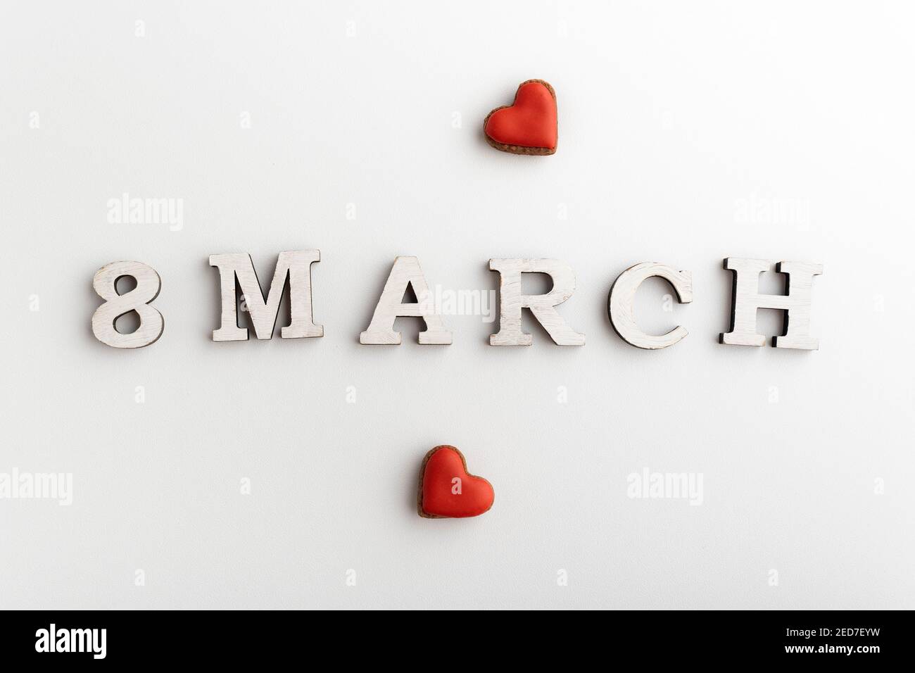 8 MARCH lettering and pink and red heart-shaped cookies on white ...