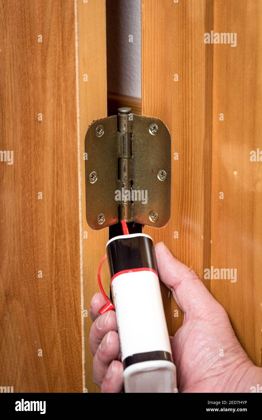 Oil can is used to add oil to a wood door hinge Stock Photo - Alamy