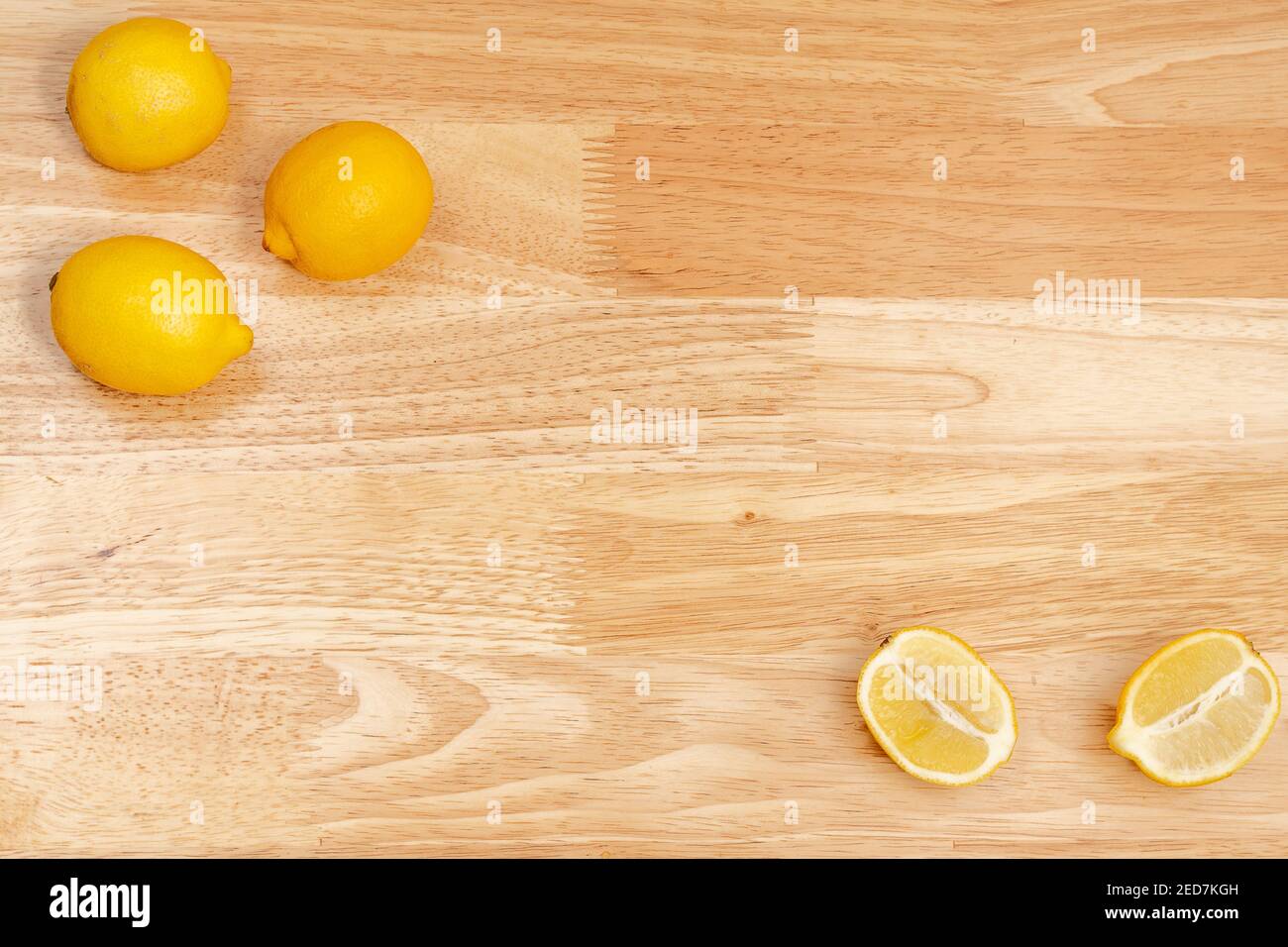 whole lemons and sliced lemons on wooden table, wooden bottom Stock ...