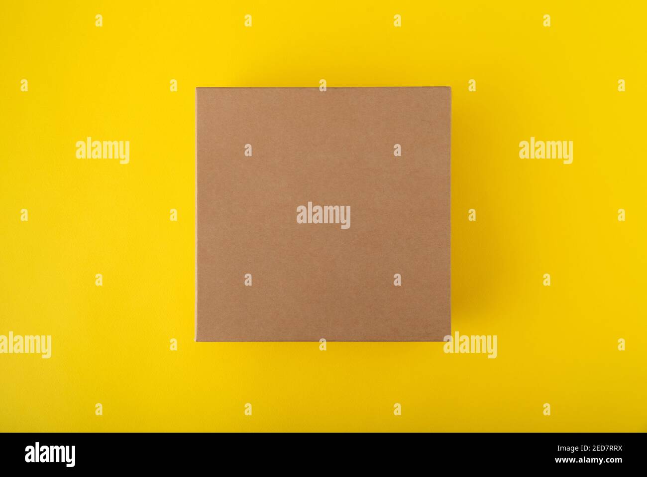 Square cardboard box on yellow background, top view. Craft box without ...