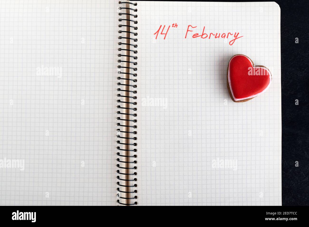 Note on notebook: 14 FEBRUARY and heart-shaped cookies. Valentine Day ...