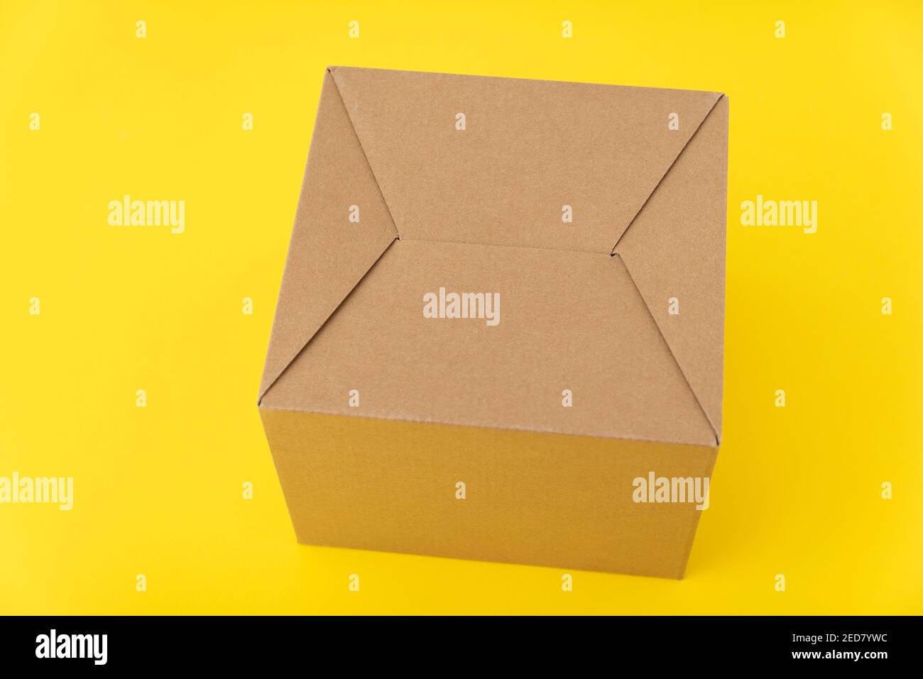 Cardboard box on yellow background. Craft packaging. Backside of parcel ...