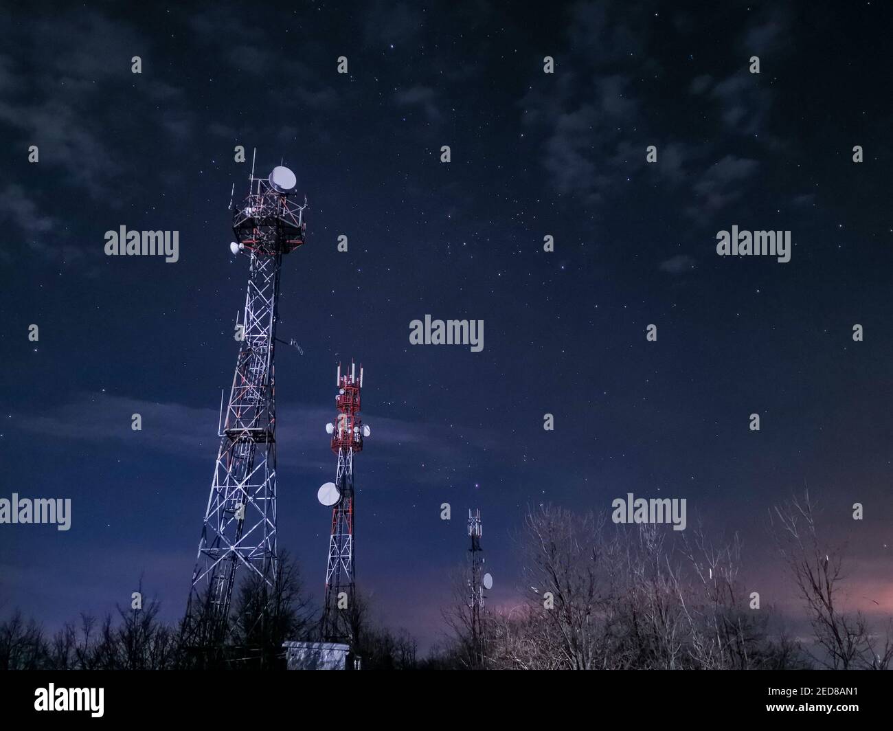 Tall telecommunication towers in the background of night starry sky ...