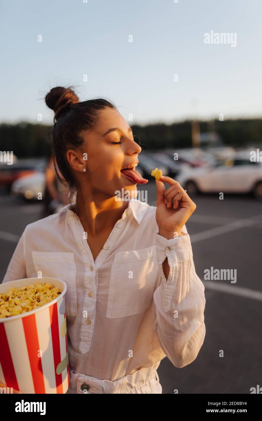 Young cute woman holding popcorn in a shopping mall parking lot Stock ...