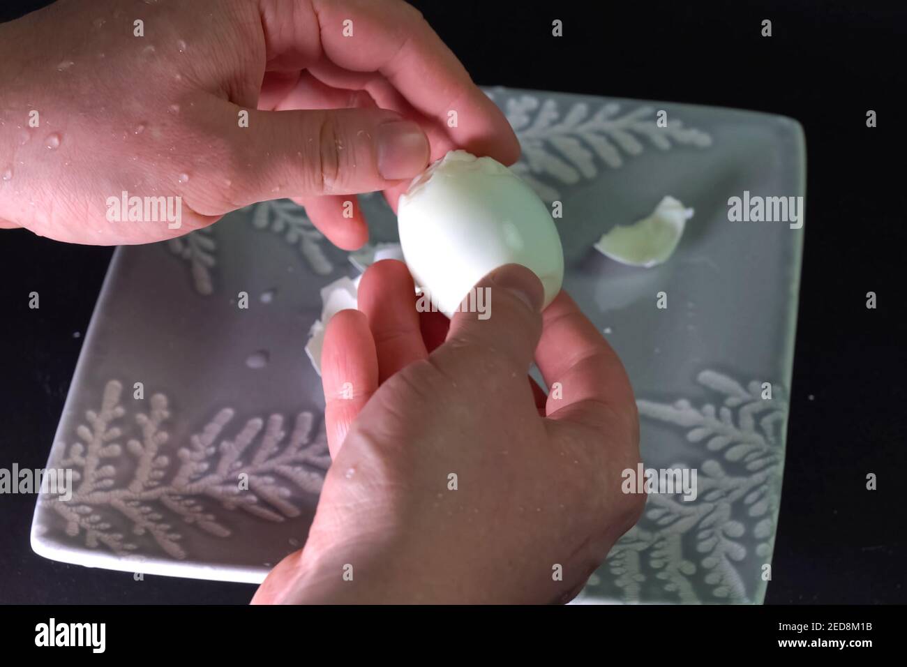 Peeling a boiled egg. A man is cleaning an egg for breakfast Stock ...