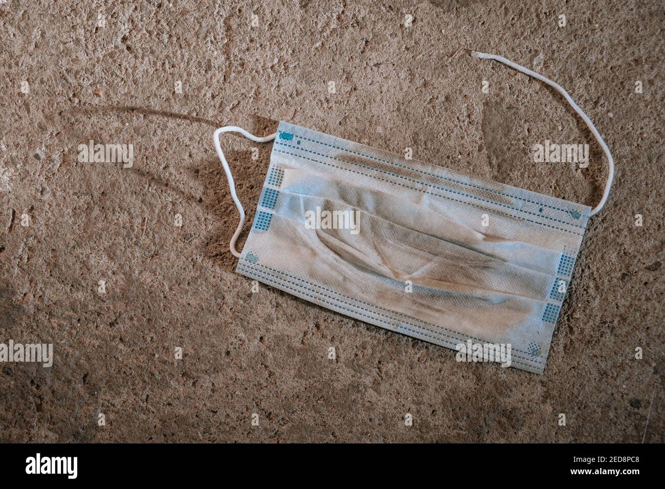 Used medical mask thrown on the ground Stock Photo - Alamy
