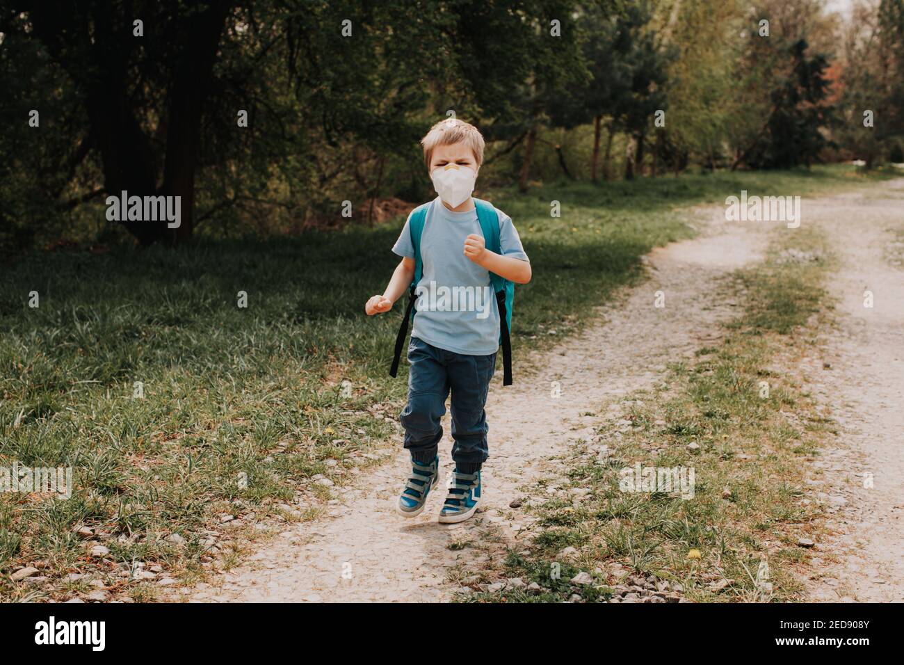 kid boy in mask with blue backpack on the way Stock Photo - Alamy