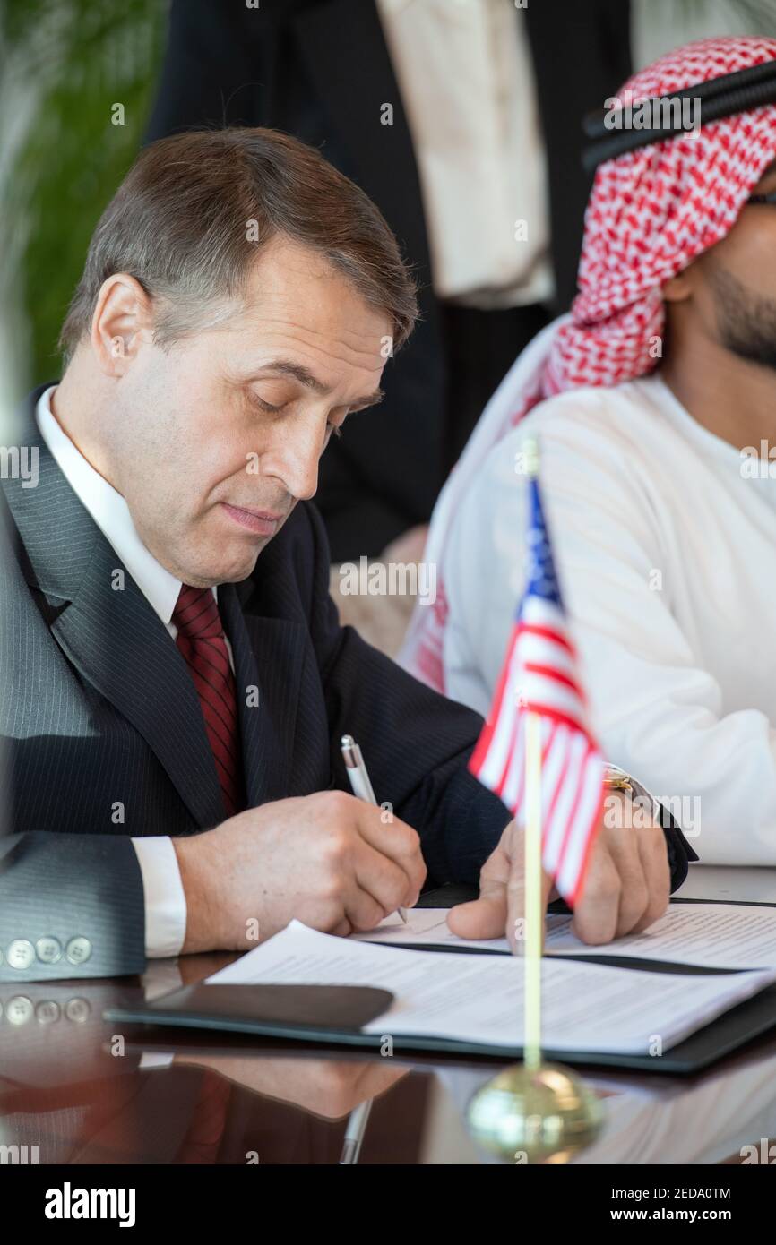 Successful American delegate in elegant suit signing contract of ...
