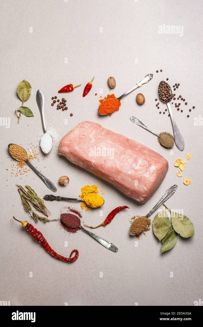 Raw pork loin and assorted spices. Fresh meat cut, aromatic powder in ...