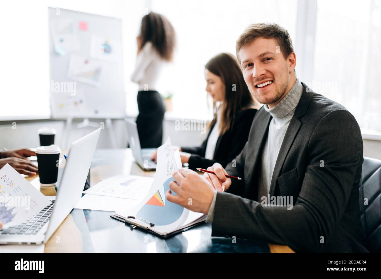 Portrait of smiling male manager in formal wear at briefing meeting ...