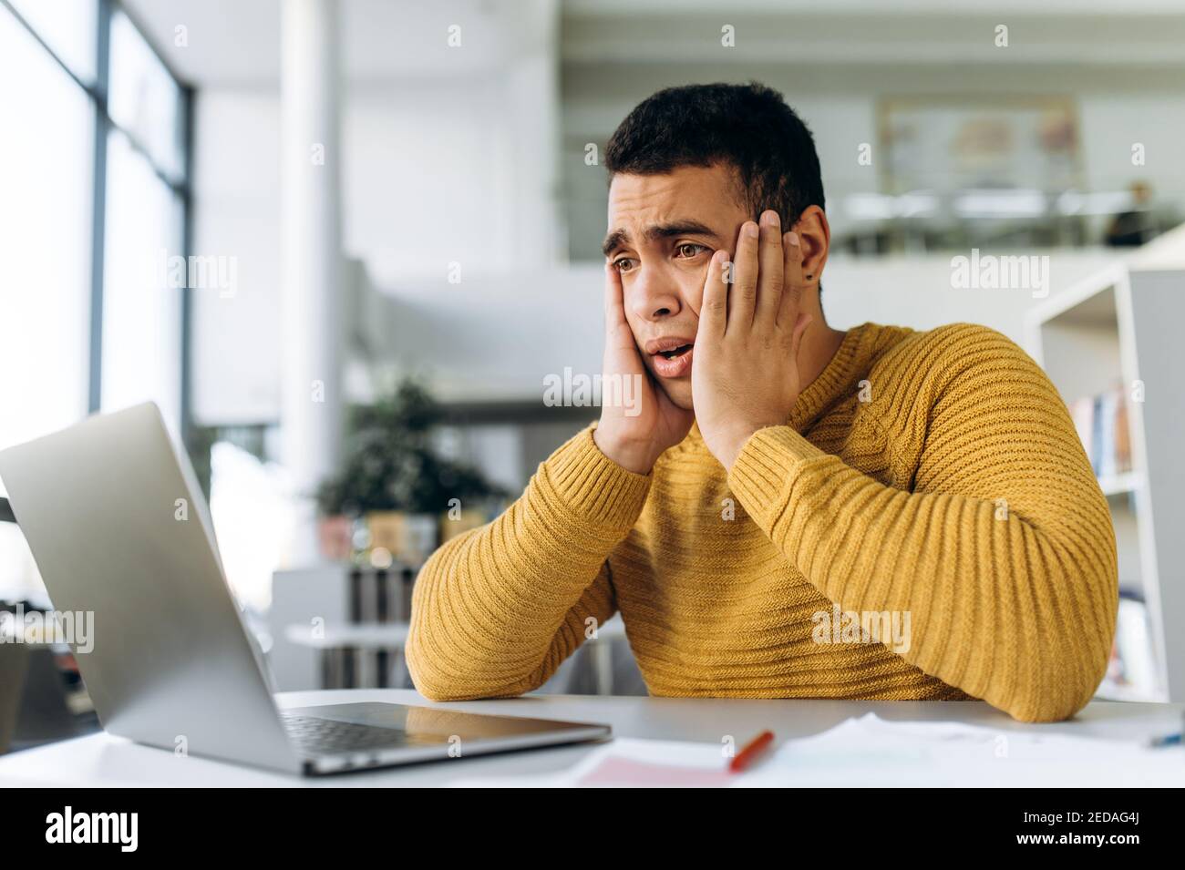 Confused hispanic male freelancer, student or coworker surprised looks ...