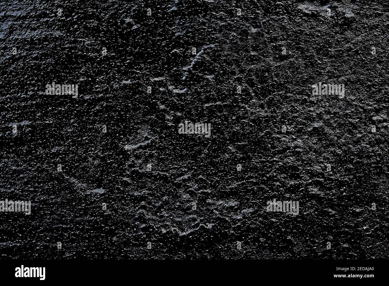 Detailed texture of black shiny resin with a rough surface and visible ...