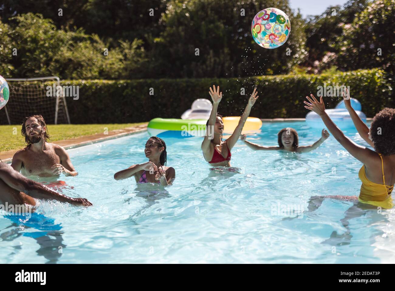 Diverse group of friends having fun in swimming pool. Hanging out and ...