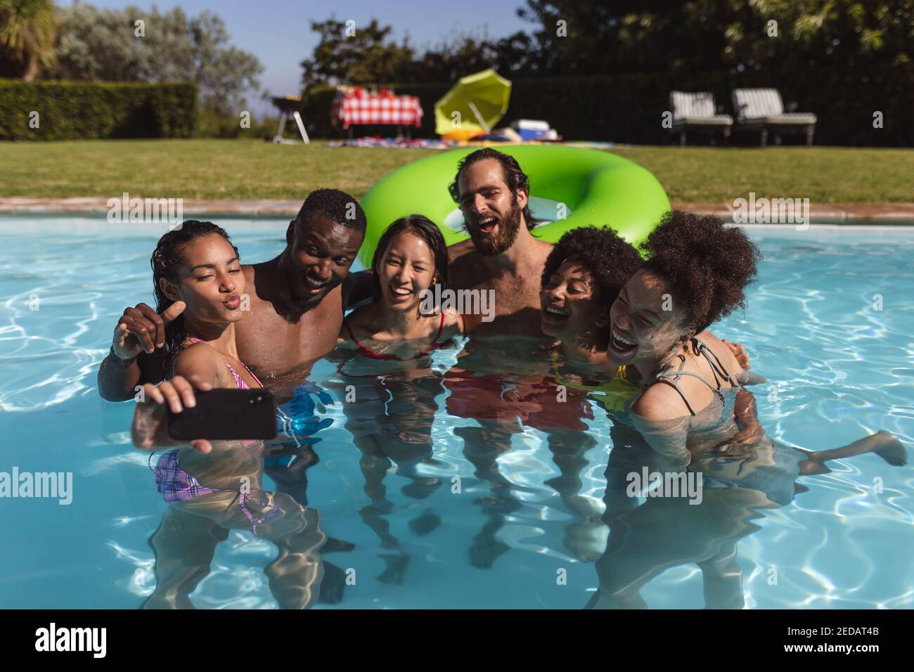 Diverse group of friends having fun and taking selfie in swimming pool ...
