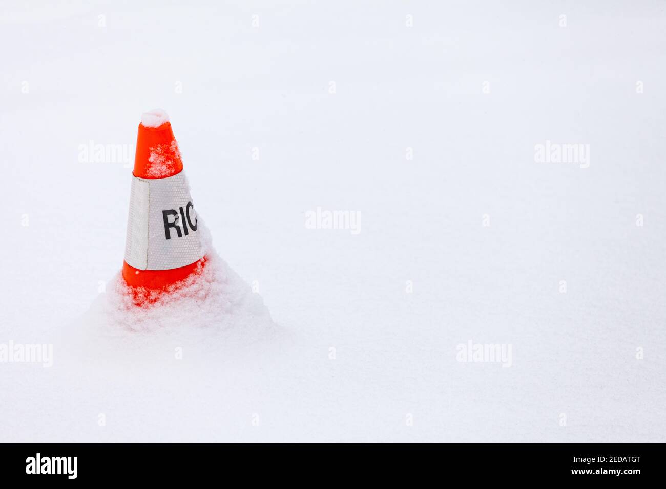 Isolated red warning cone under a light snowfall in Richmond British ...