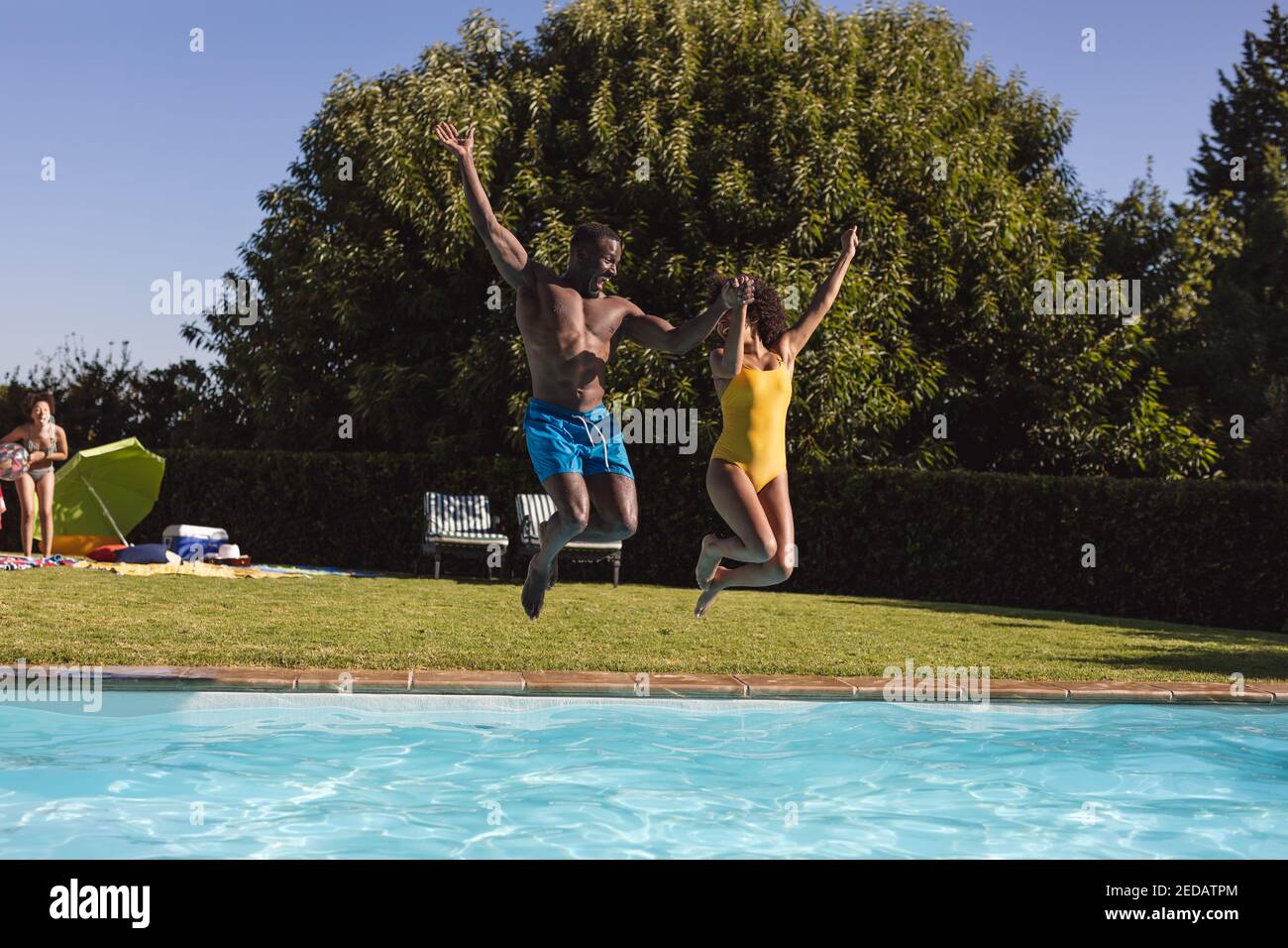 Two diverse male and female friends having fun and jumping into ...