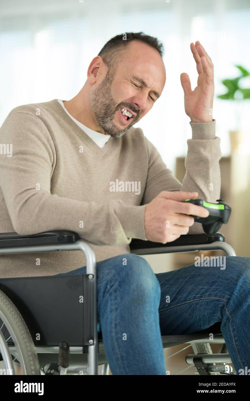 upset disabled man playing computer games Stock Photo - Alamy